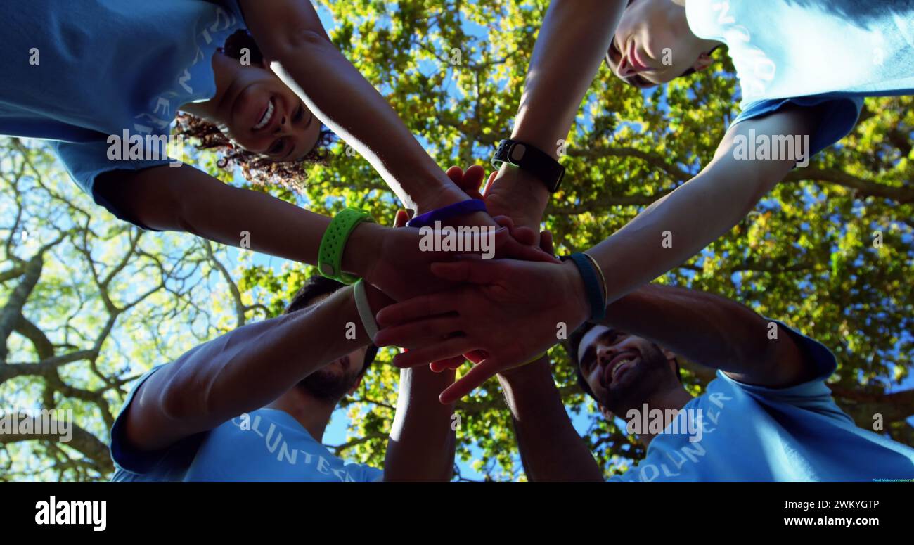 Diverse group of volunteers stack hands outdoors, with copy space Stock ...