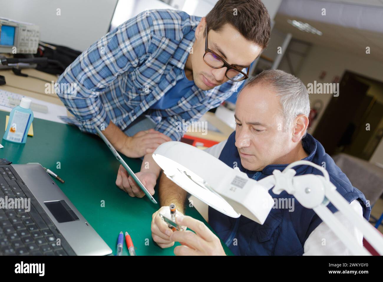engineer and collegue with magnifier in hands Stock Photo - Alamy