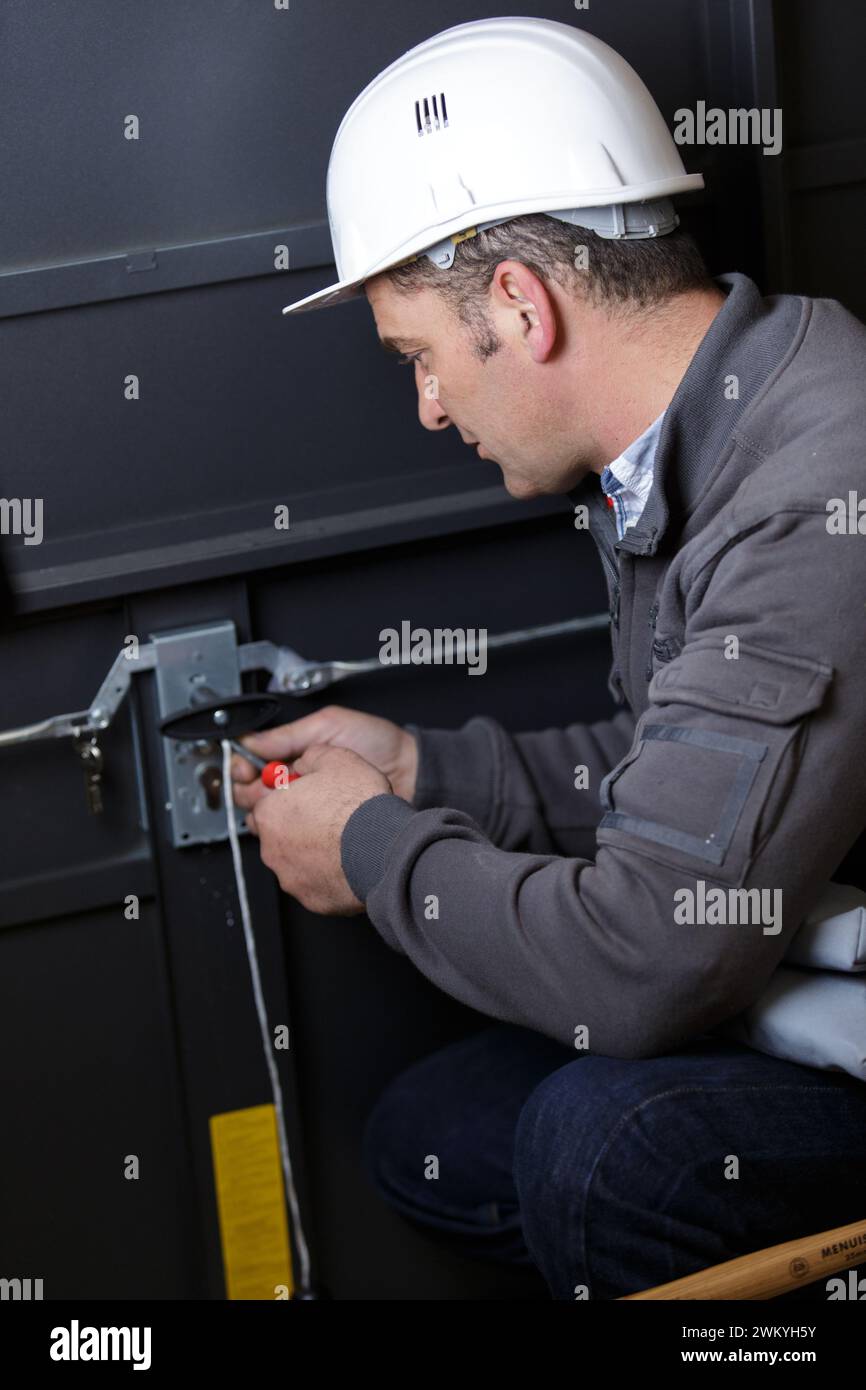 workman repairing a garage door Stock Photo - Alamy