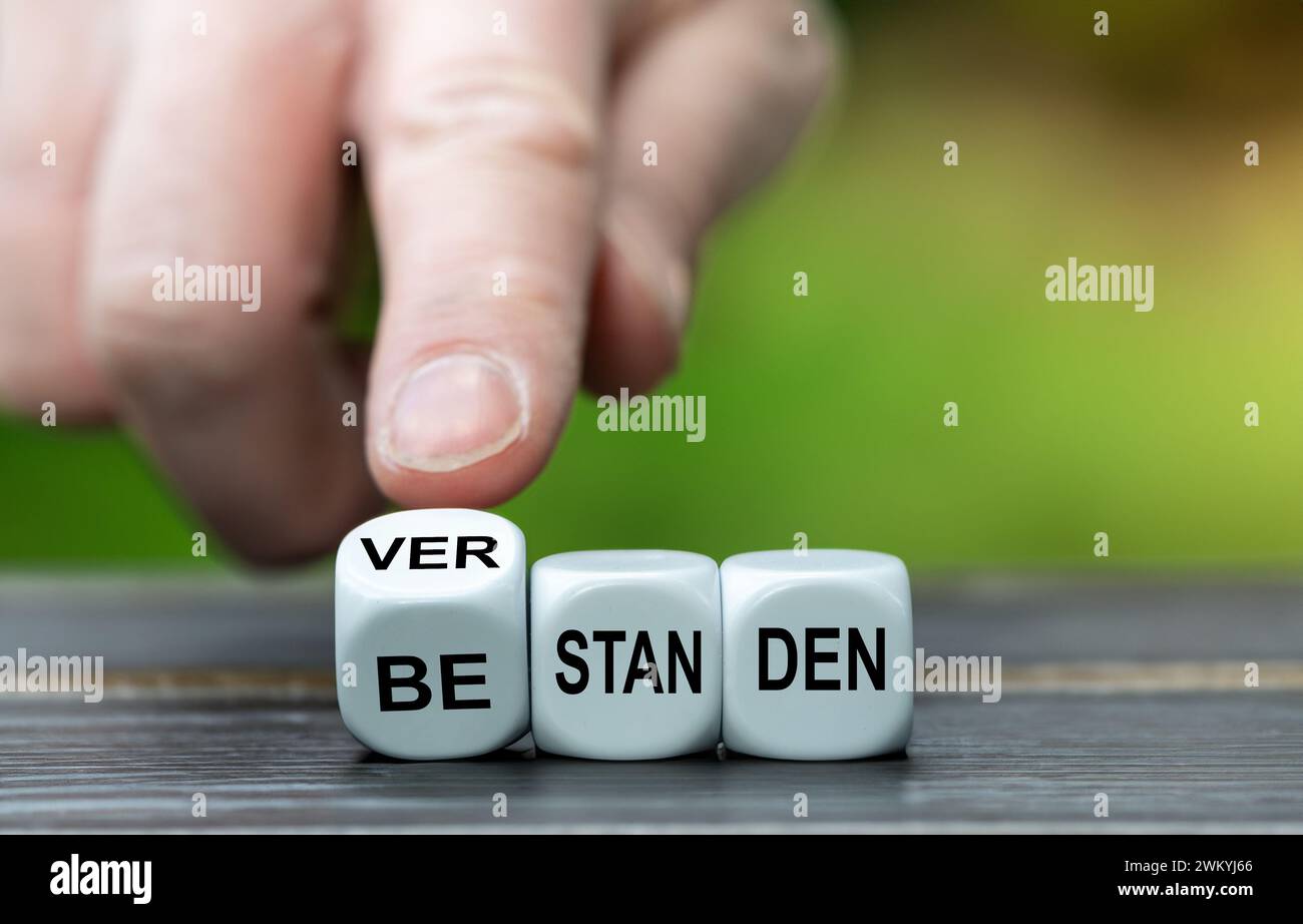 Hand turns dice and changes the German word 'bestanden' (passed) to ...