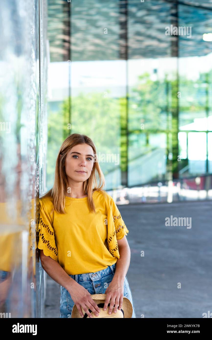 A candid moment captured of a young woman smiling, dressed in a summer ...