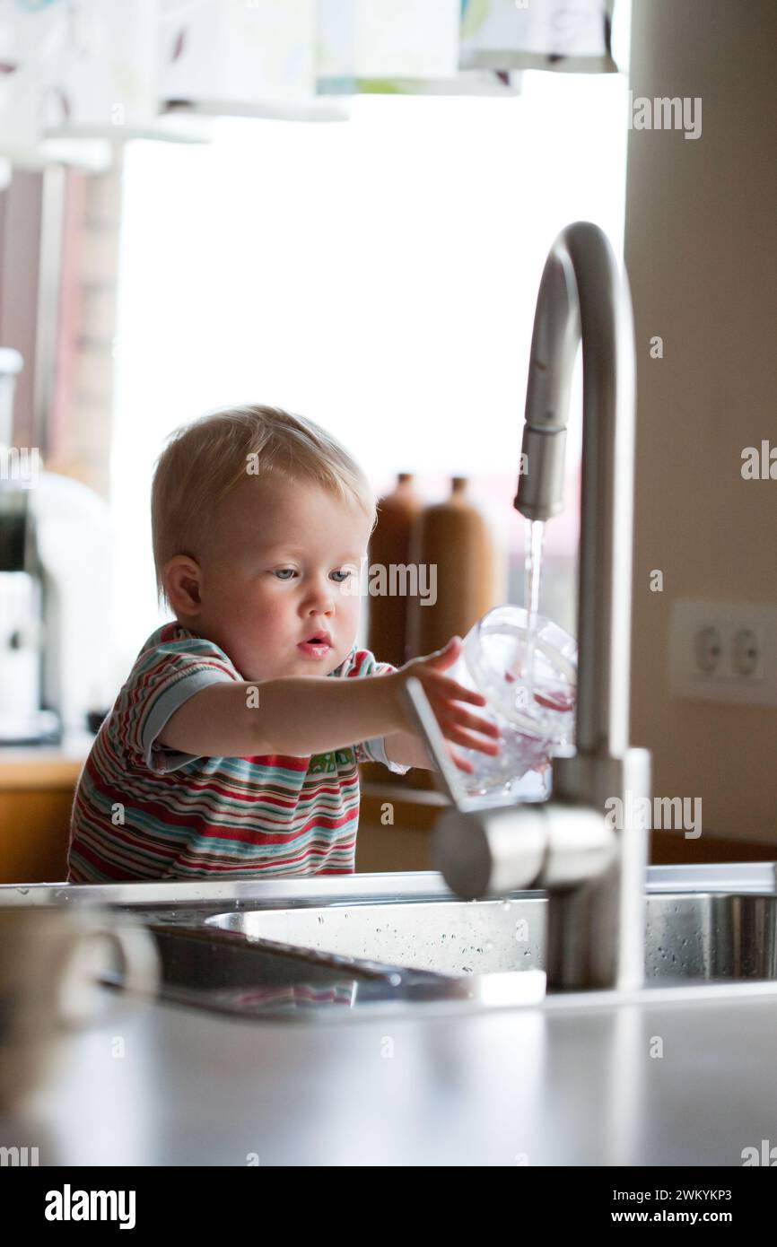 Toddler Playing in Kitchen Stock Photo - Alamy
