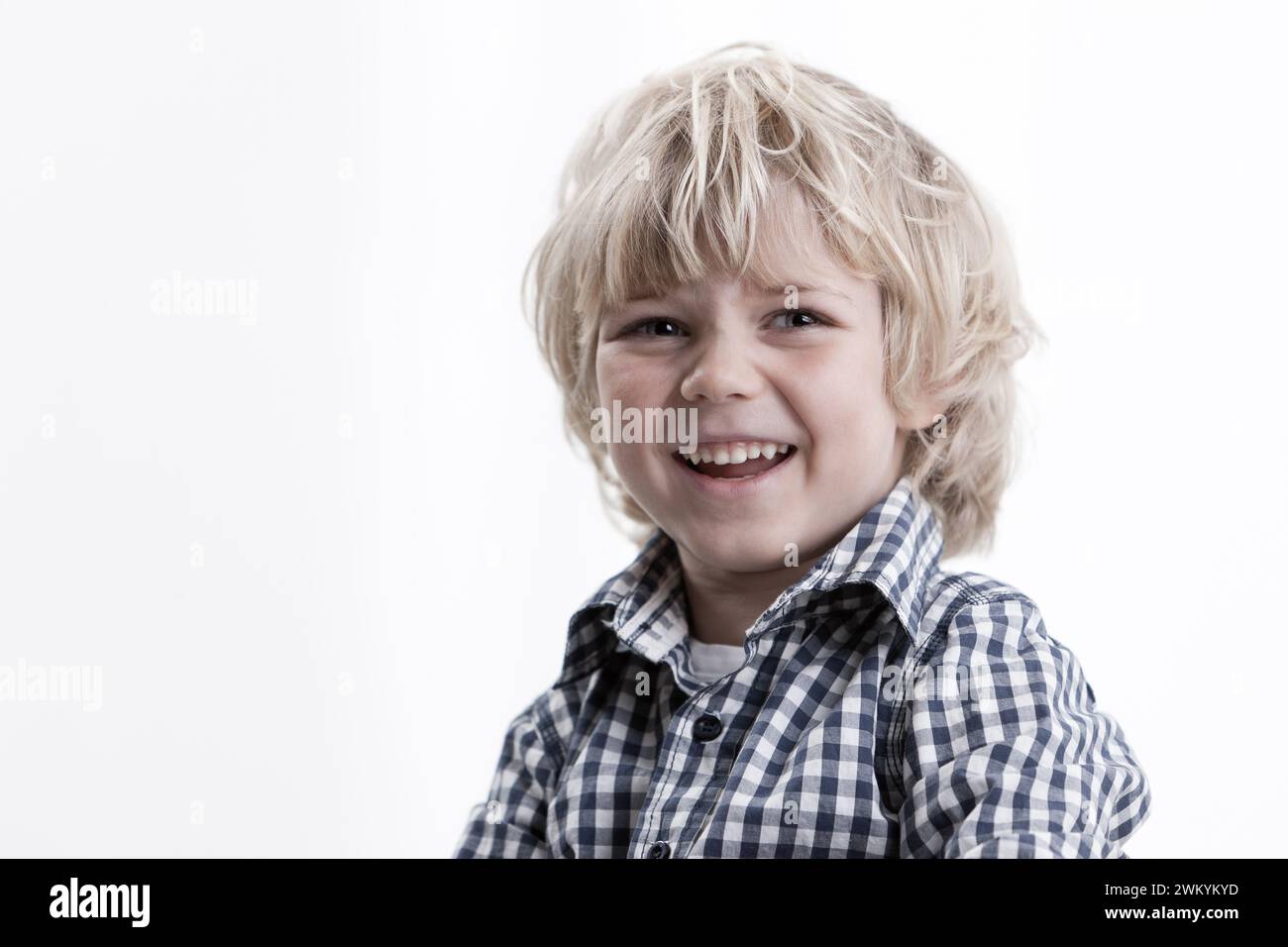 A laughing young boy looking in camera, white background Stock Photo ...