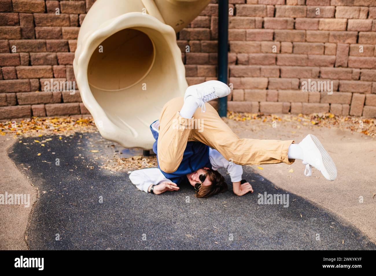 Playful tumble from playground slide Stock Photo - Alamy
