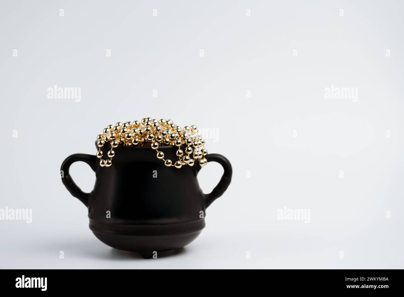 Black cauldron pot with gold beads on white background. Design element ...