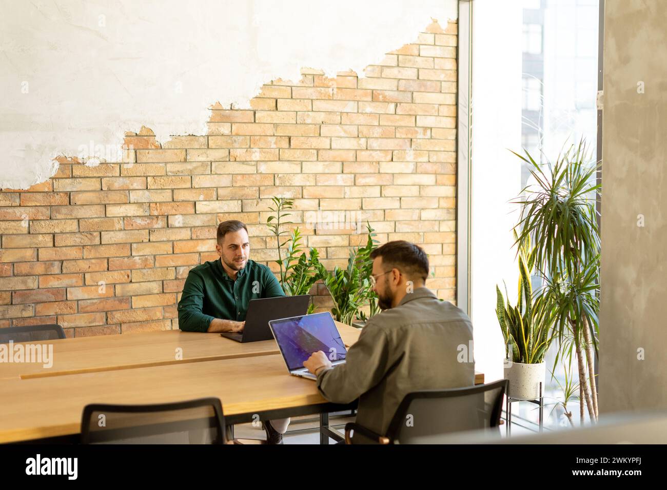 Two smiling professionals engage in a collaborative work session at a ...