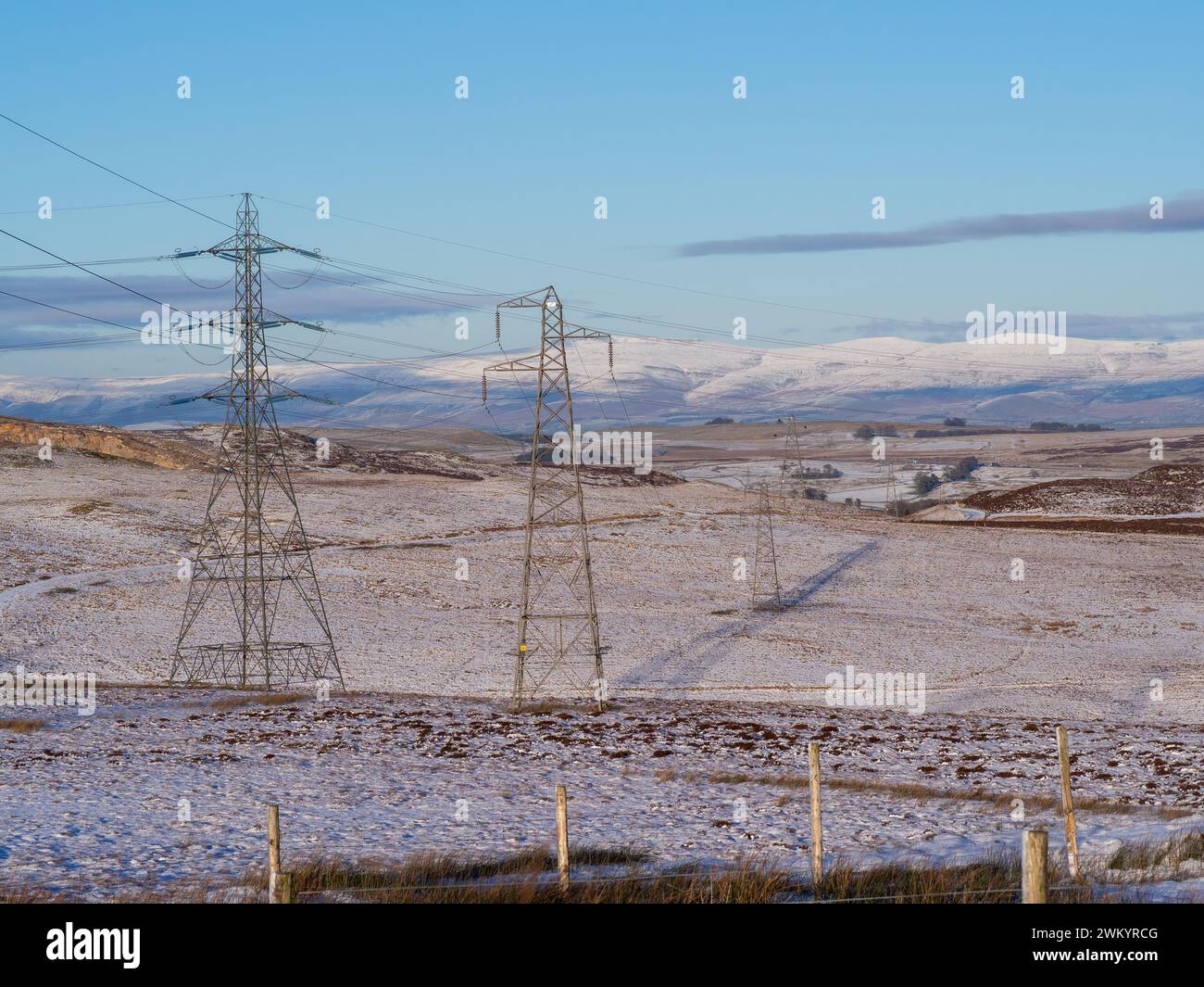 Electricity pylons stretching off into the distance over the snow ...