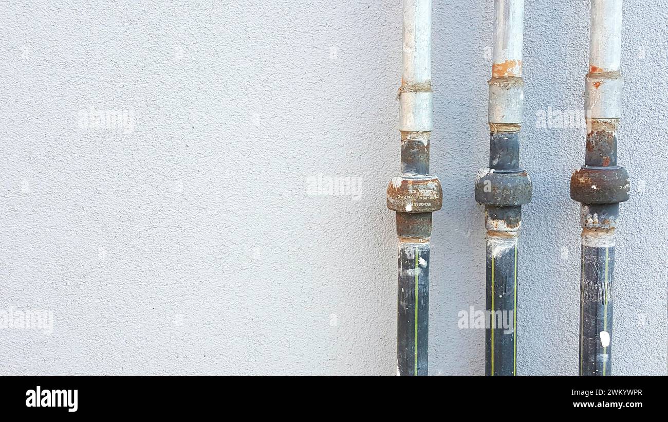 Three rusty pipes, one for gas, one for water, and one for wood, are ...