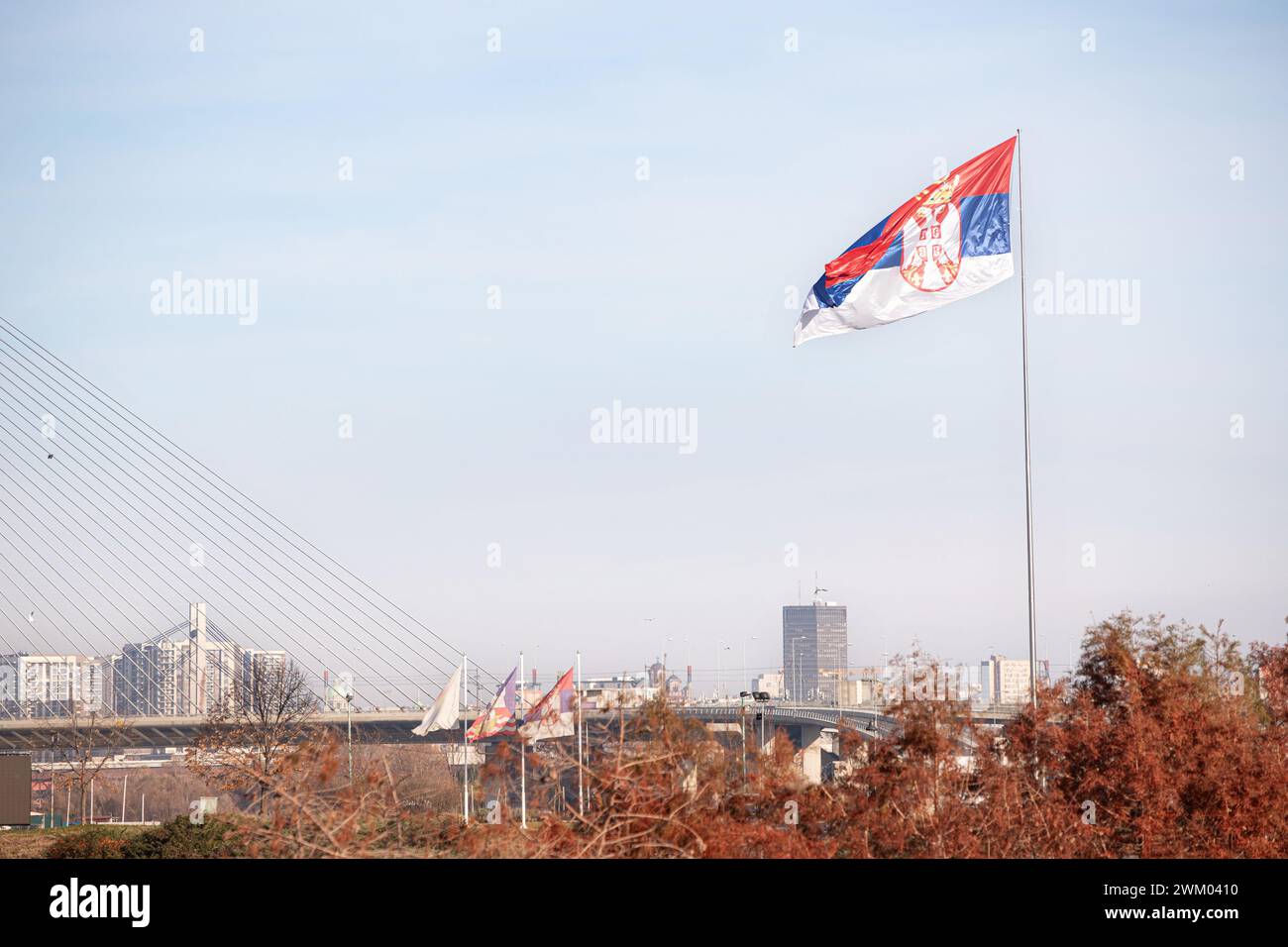 The Serbian flag waves proudly against a clear blue sky, symbolizing ...