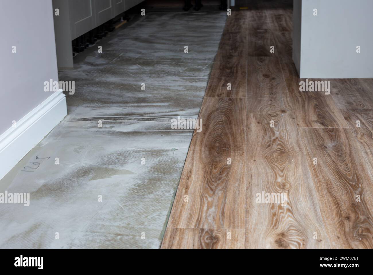 Contrast of installed wooden laminate flooring next to bare subfloor in ...