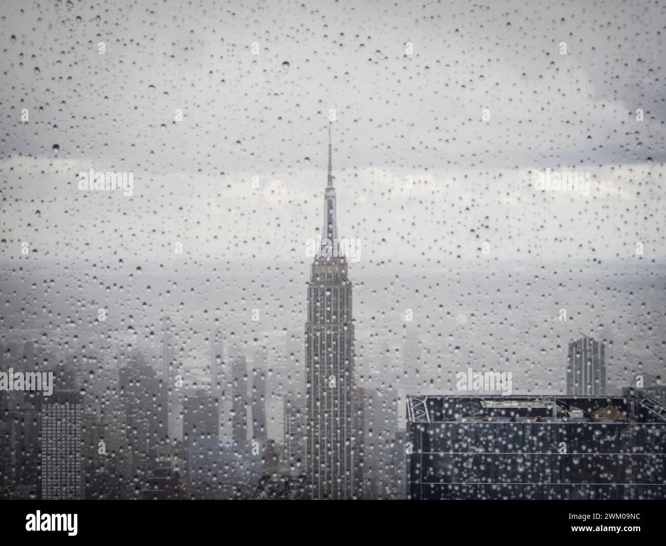 The Empire State Building in the rain, seen through a window with ...