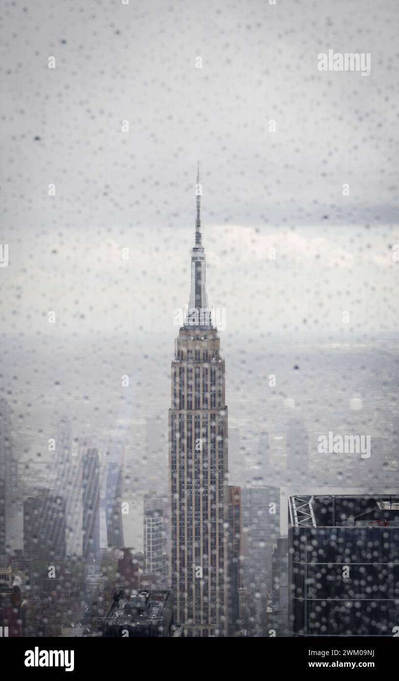 The Empire State Building in the rain, seen through a window with ...