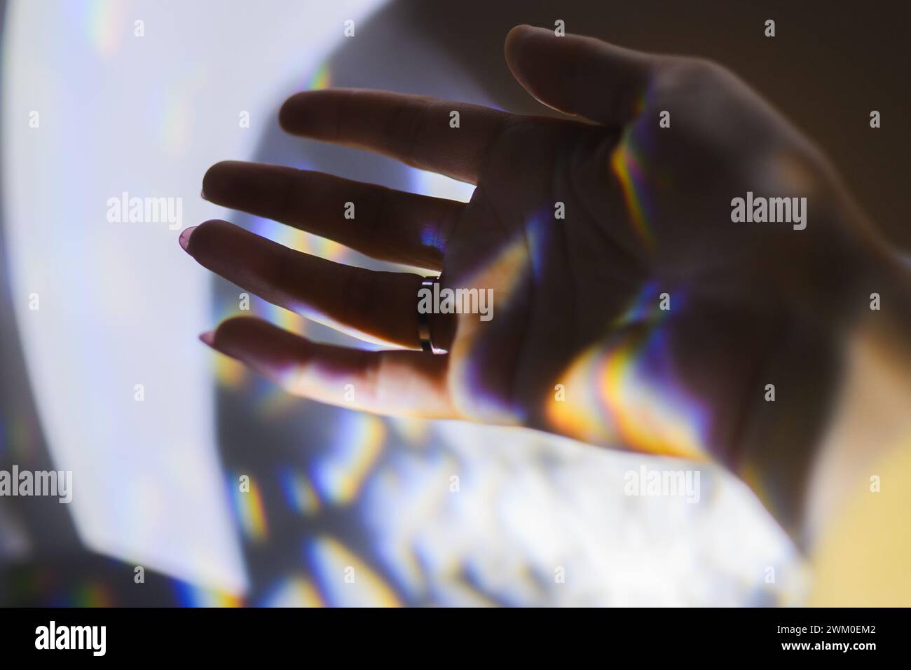 A hand is illuminated by a light through a circular glass window Stock ...