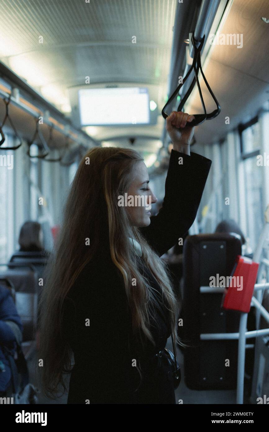 A woman with flowing long hair holds onto bus handrails Stock Photo - Alamy