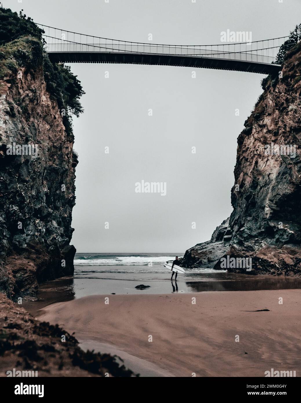 A man strolls on the beach below a bridge overpass, UK Stock Photo - Alamy