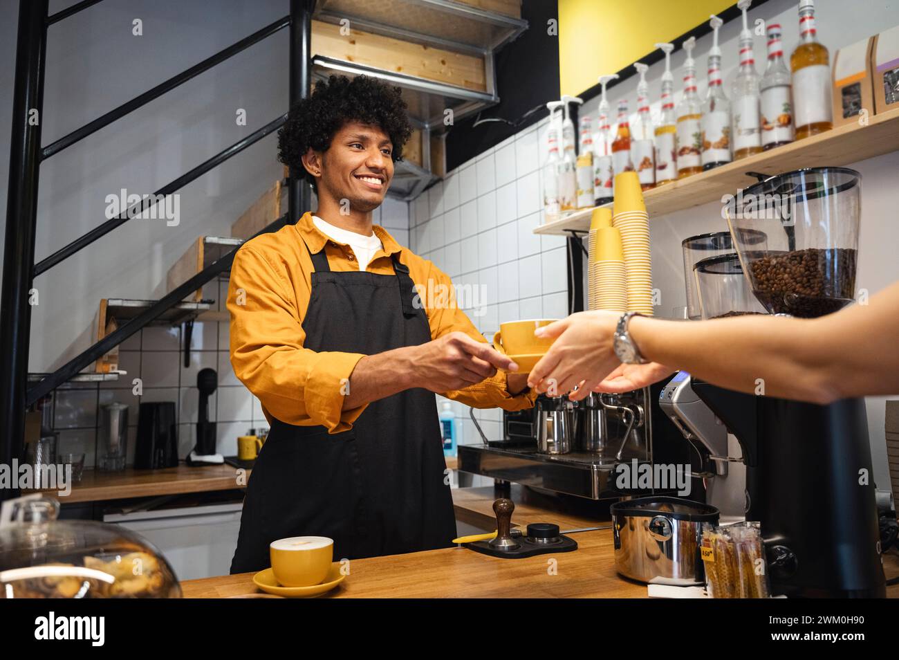 Smiling barista serving coffee to customer at cafe Stock Photo - Alamy