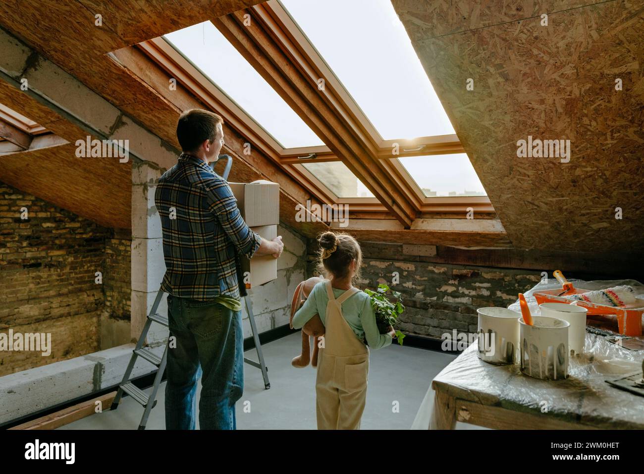 Father and daughter looking at window in room under renovation Stock ...