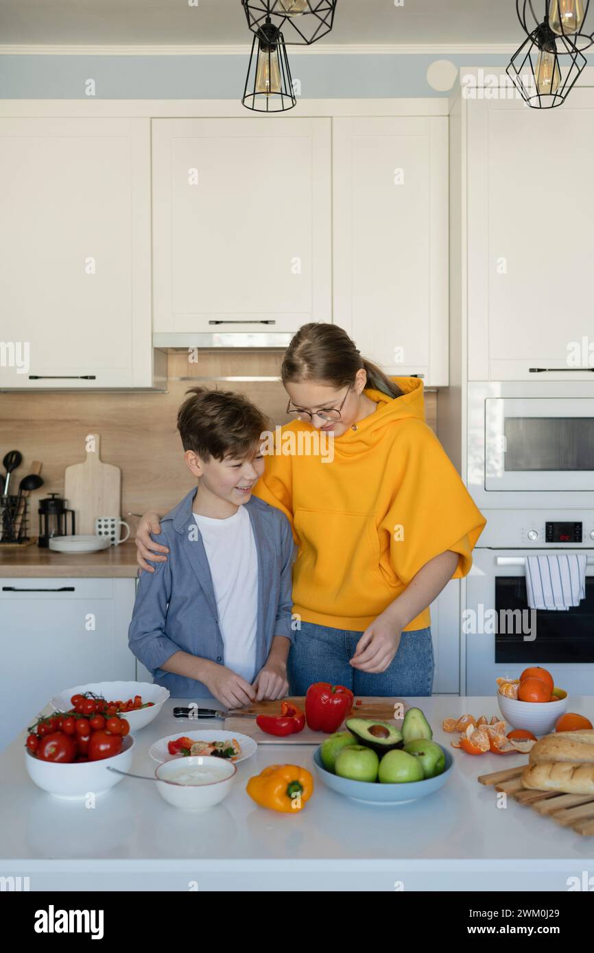 Happy siblings preparing food in kitchen at home Stock Photo - Alamy