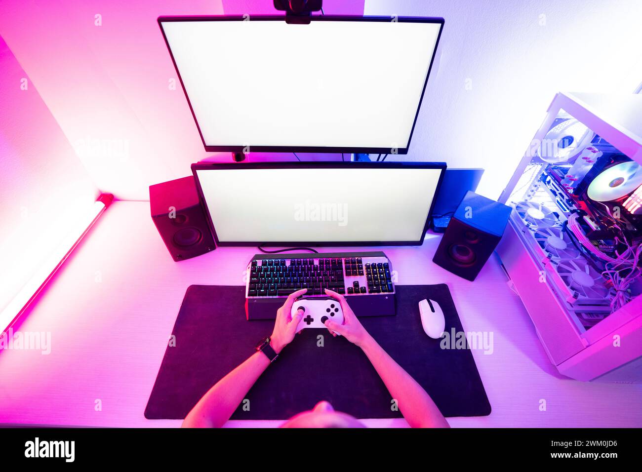 Hands of gamer holding gaming console and playing video game on desktop ...