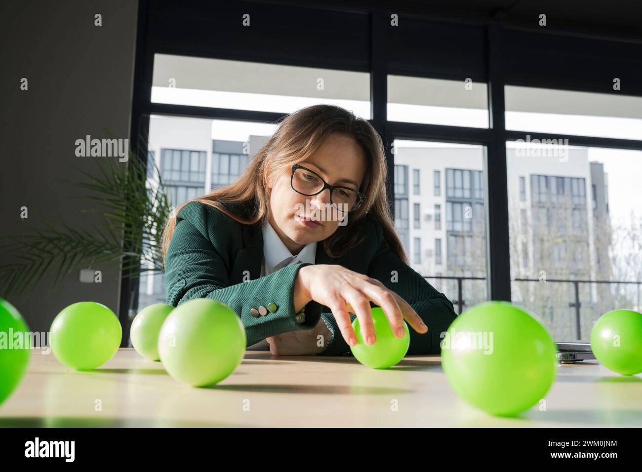 Thoughtful businesswoman touching ball kept on desk in office Stock ...