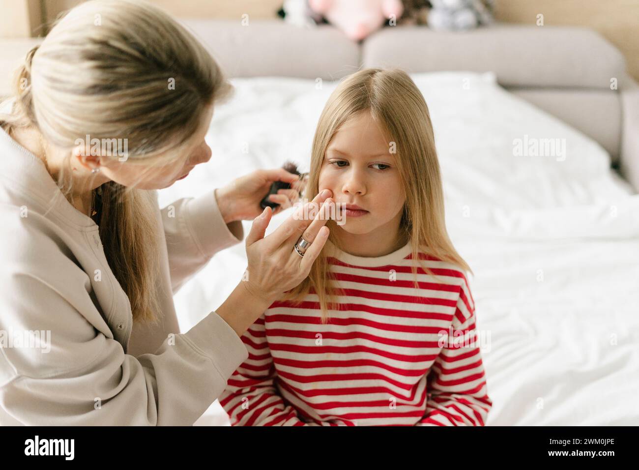 Woman touching daughter's cheeks at home Stock Photo - Alamy
