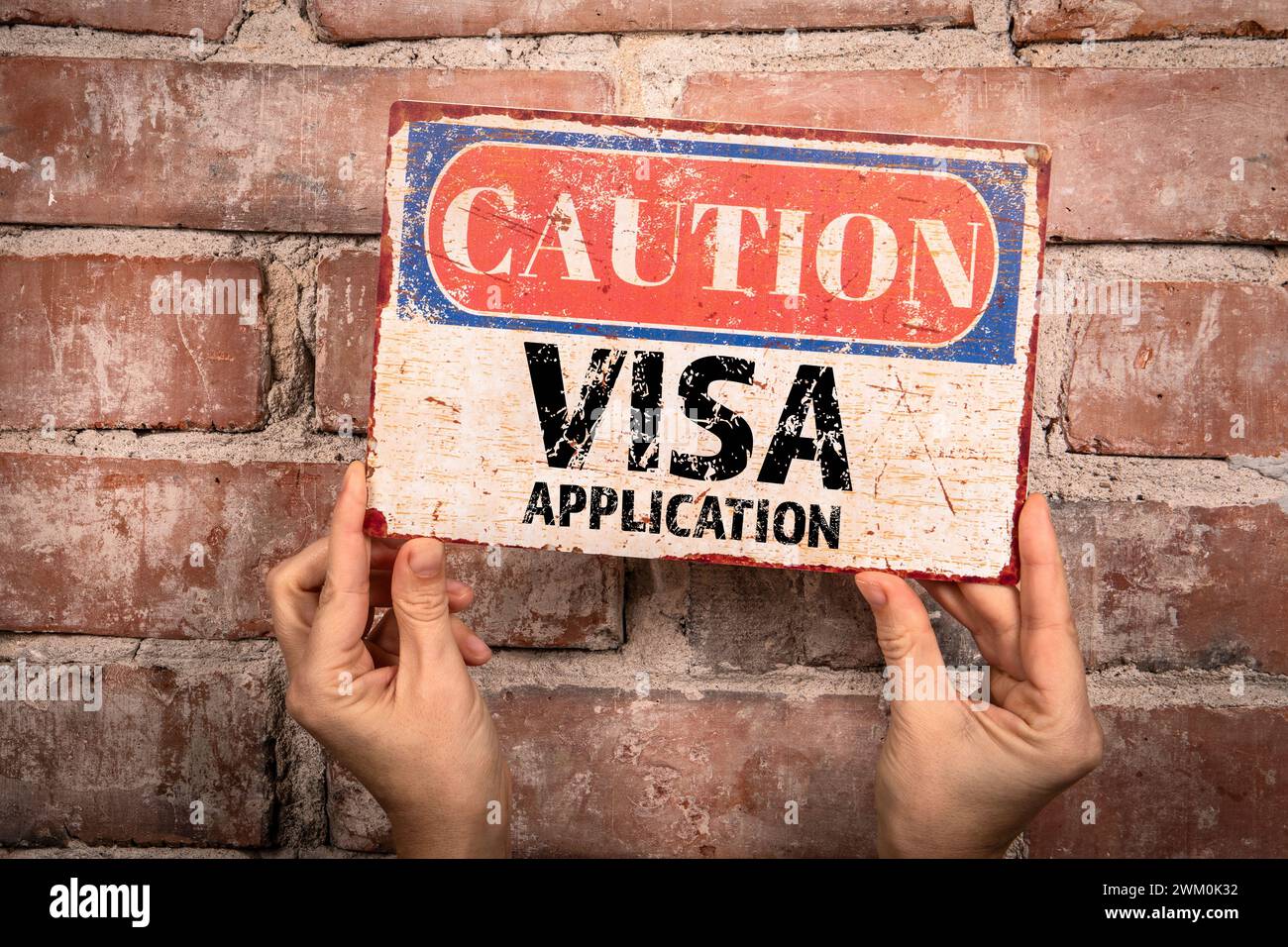 VISA Application. Caution sign in a woman's hand on a brick background ...