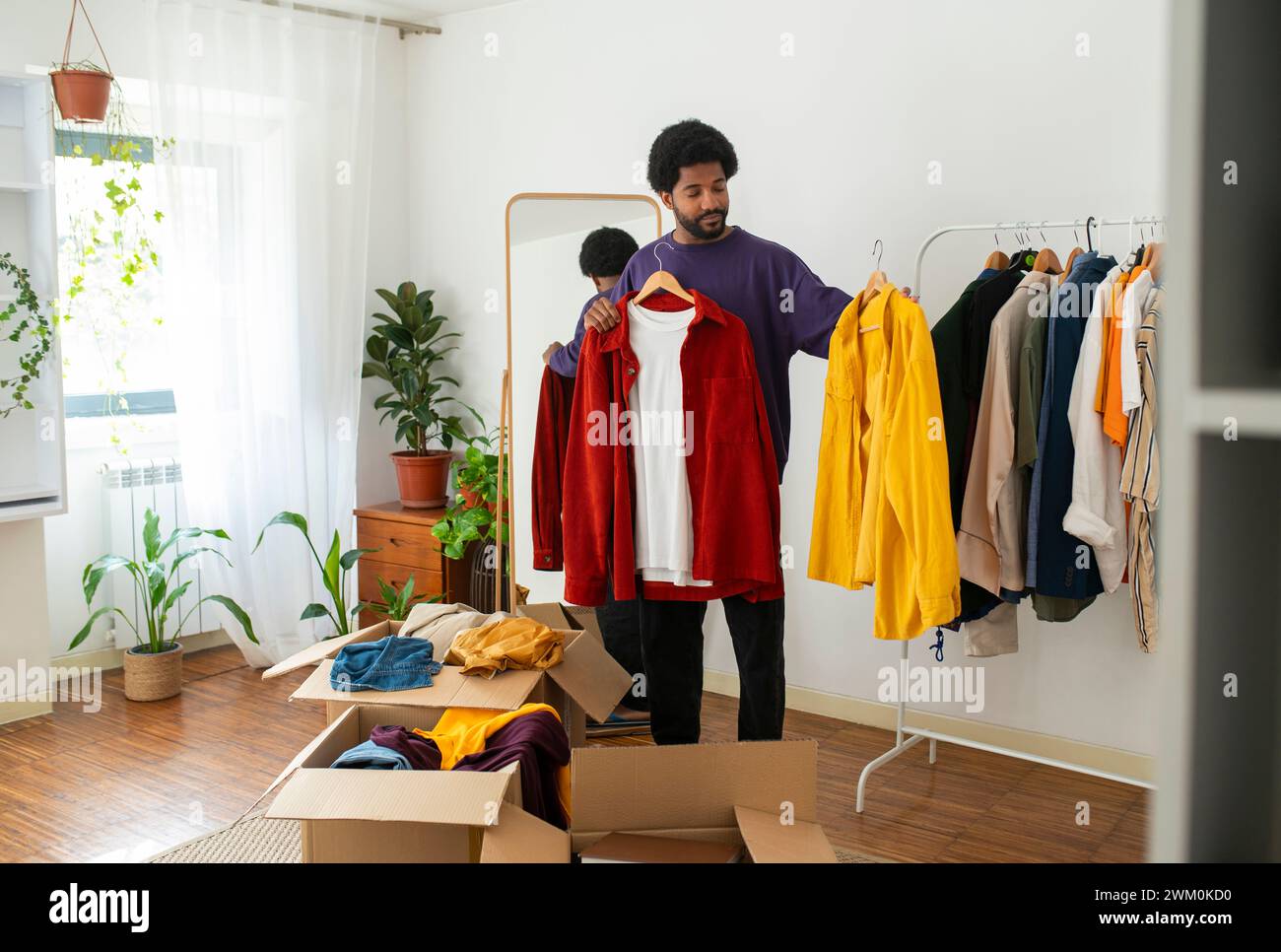 Man organizing and decluttering clothes at home Stock Photo - Alamy