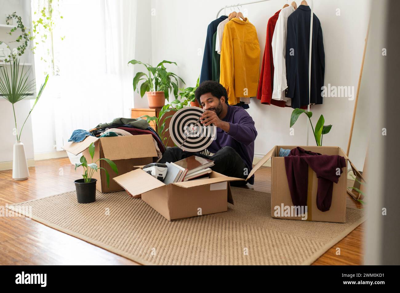 Young man organizing clothes and objects in cardboard boxes Stock Photo ...