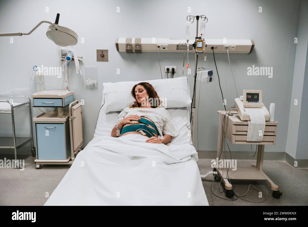 Pregnant woman lying on bed in delivery room Stock Photo - Alamy