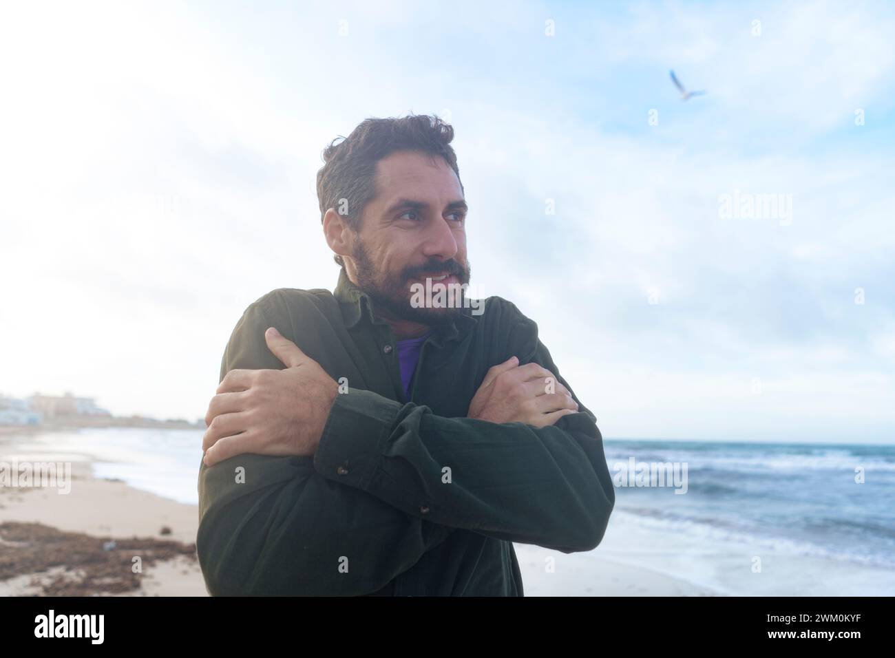Happy man shivering and feeling cold at beach Stock Photo - Alamy