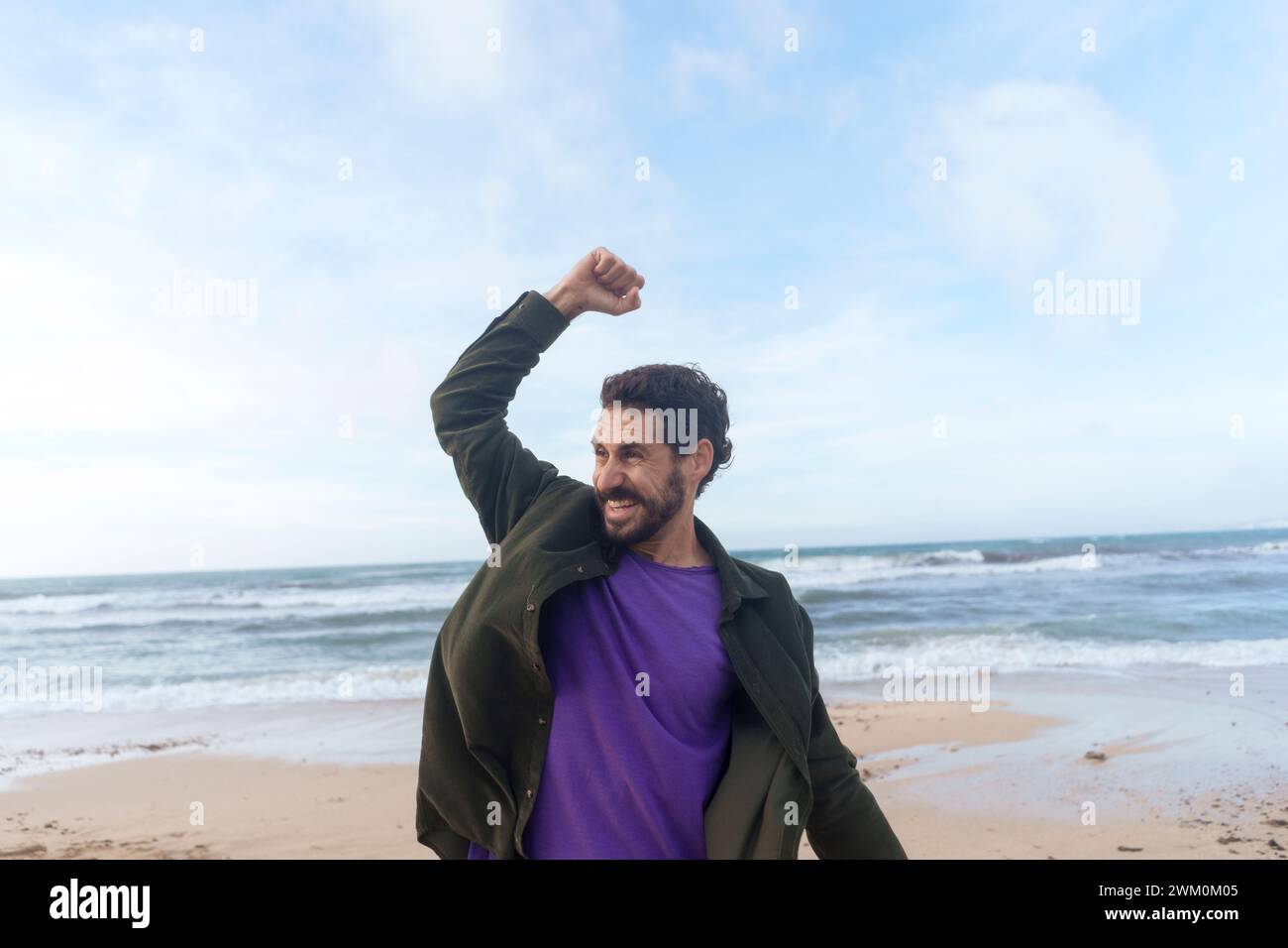 Happy man cheering in front of sea at beach Stock Photo - Alamy
