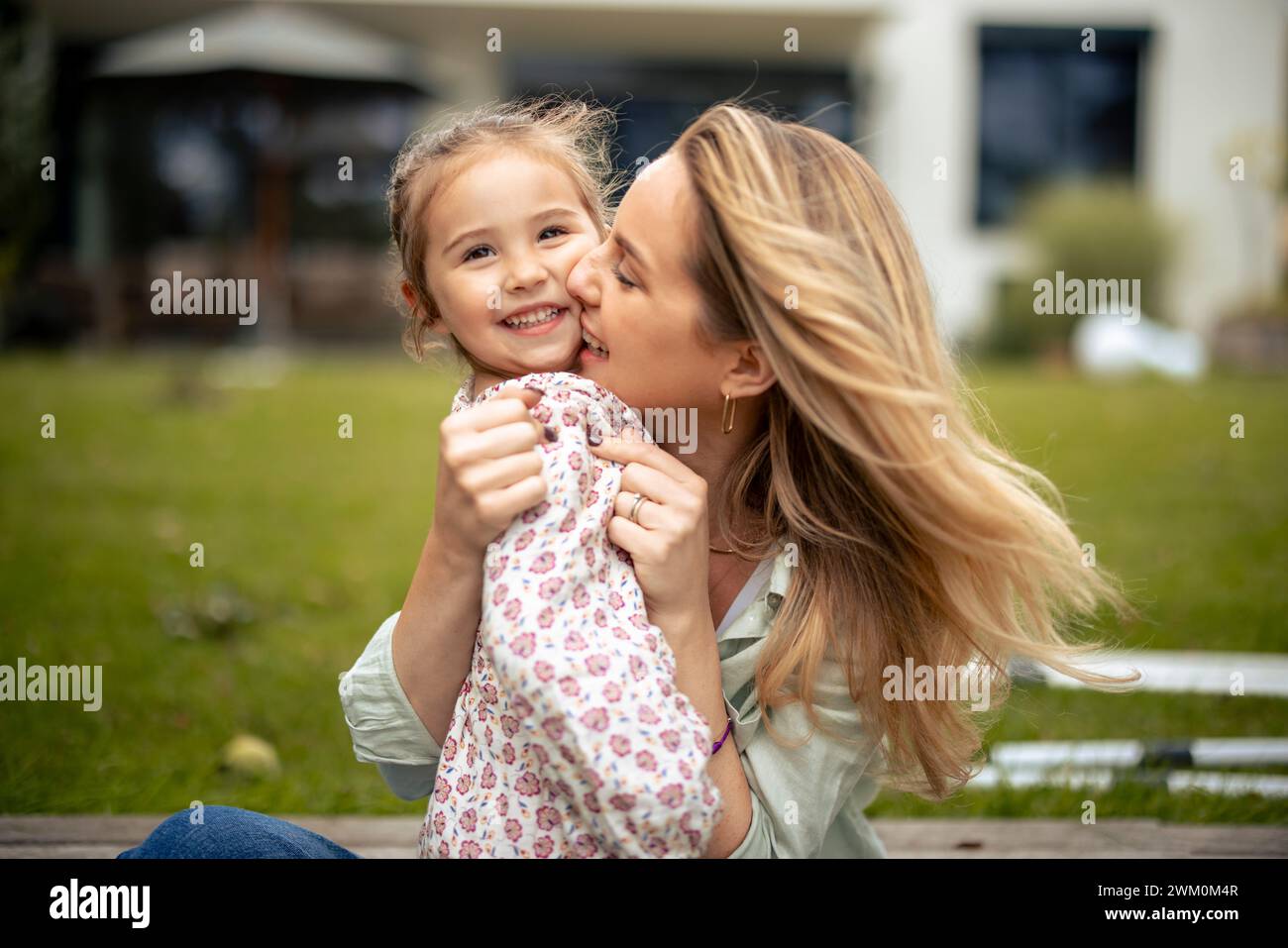 Blond mother kissing daughter hi-res stock photography and images - Alamy