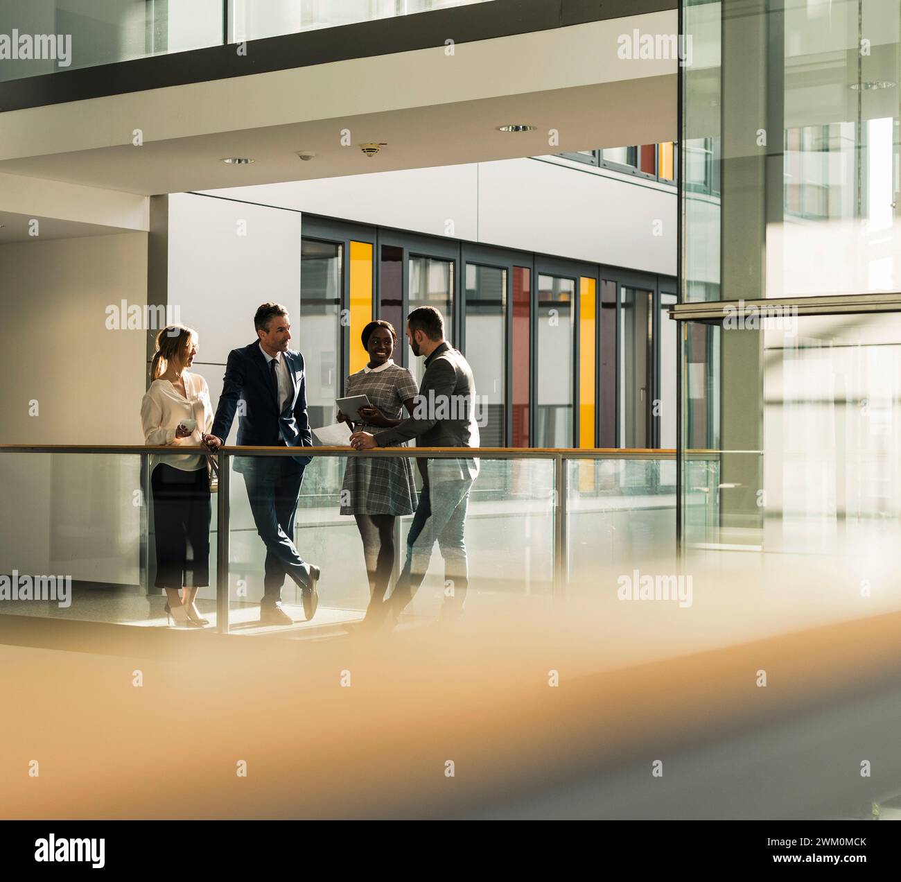 Business colleagues talking on walkway at office Stock Photo - Alamy