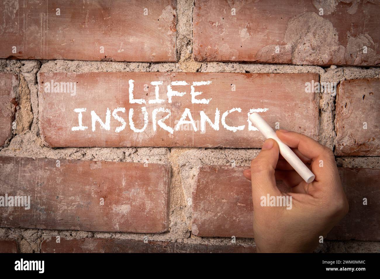 Life Insurance. Text written with white chalk on a red brick background ...