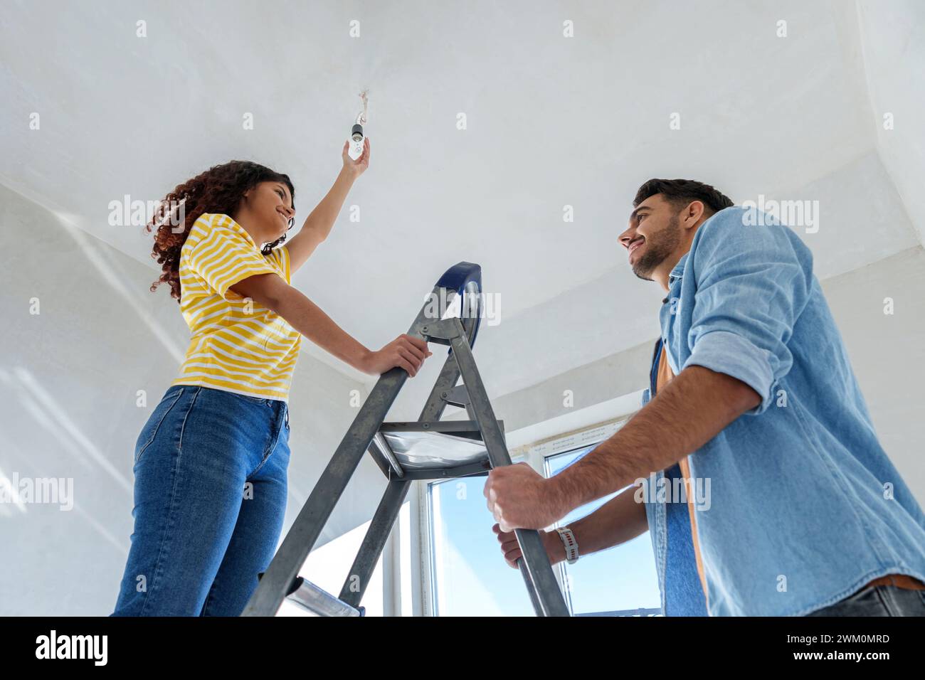 Woman changing light bulb hi-res stock photography and images - Alamy