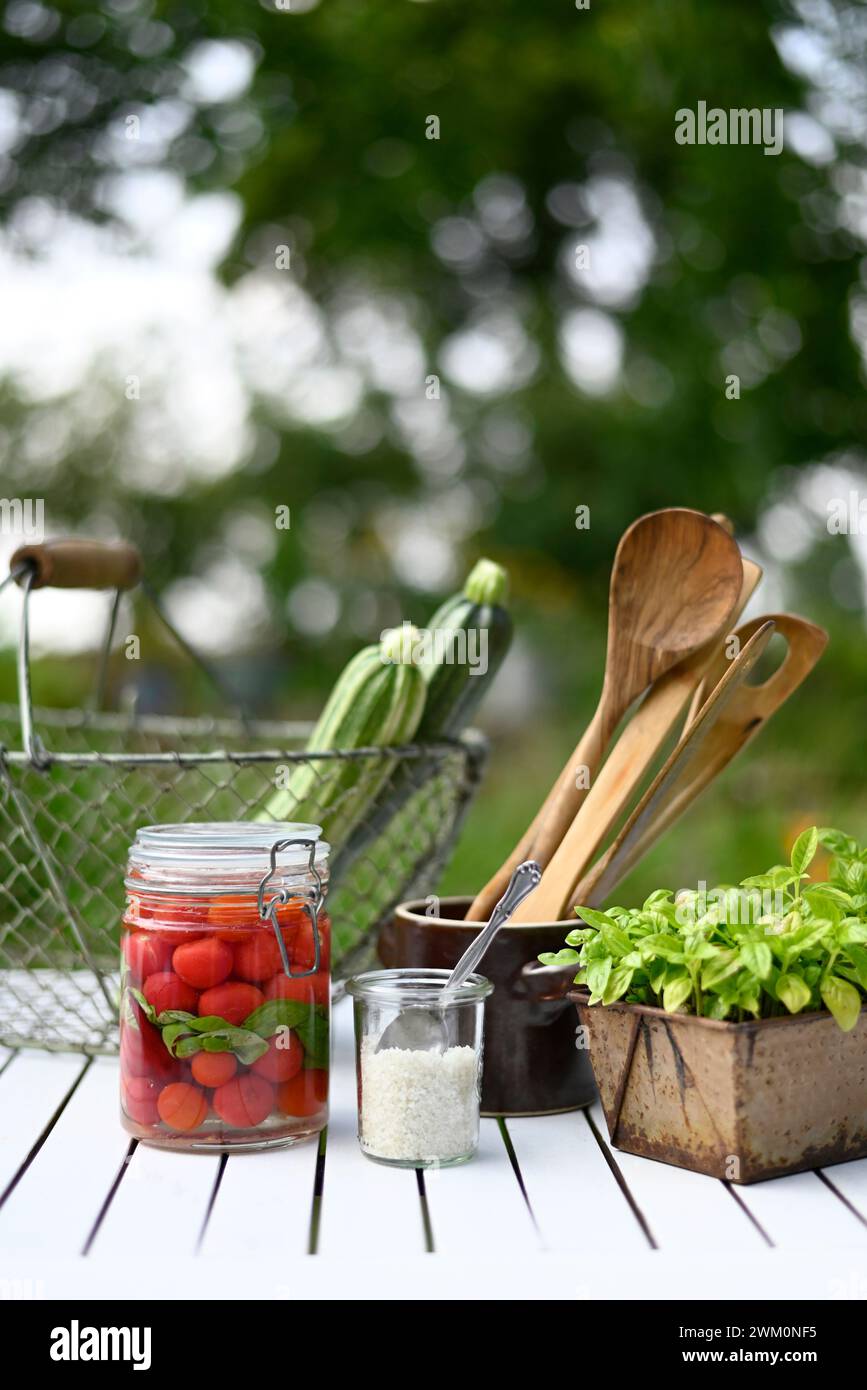 Cherry tomatoes preserved in brine near basil plant Stock Photo - Alamy