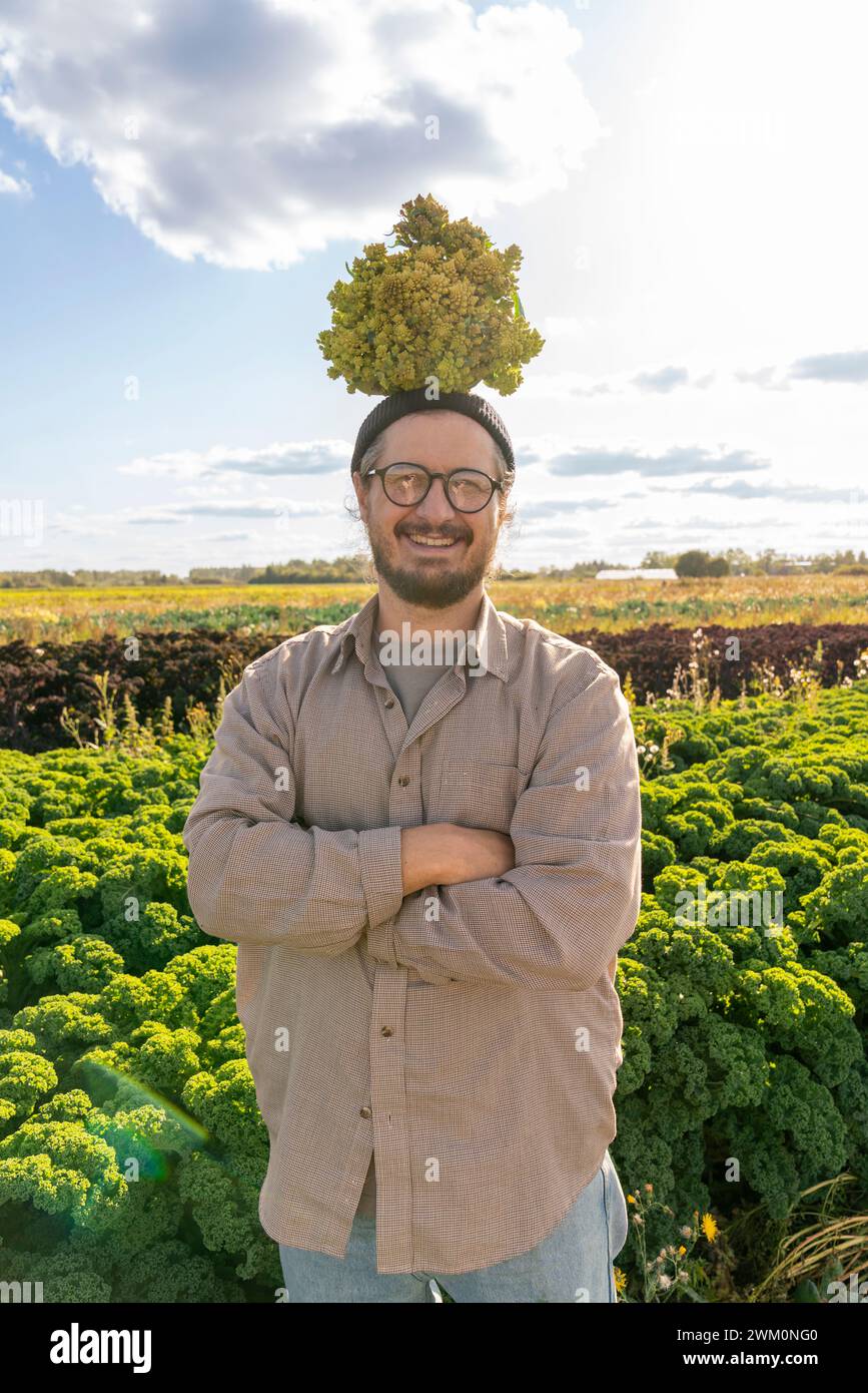 Smiling farmer balancing Romanesco cauliflower on head in farm Stock ...