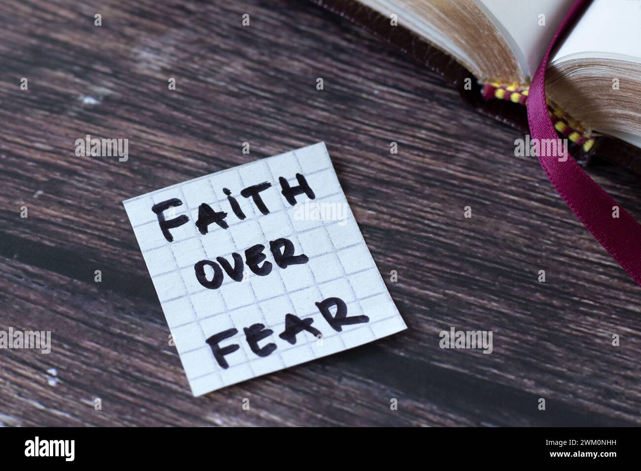 Faith over fear, handwritten text with open holy bible book on wood ...
