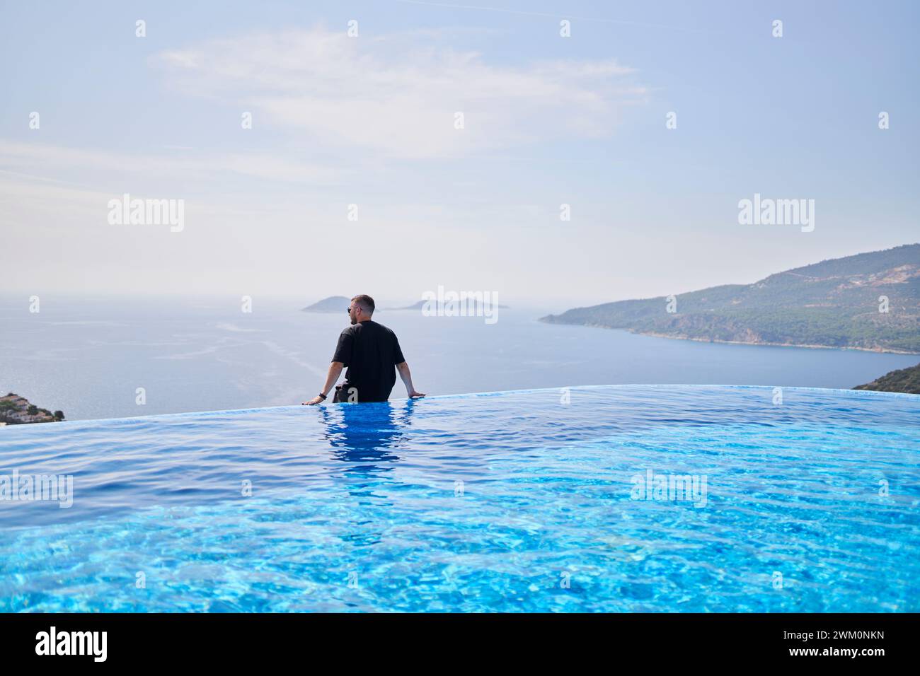 Man sitting by swimming pool hi-res stock photography and images - Alamy