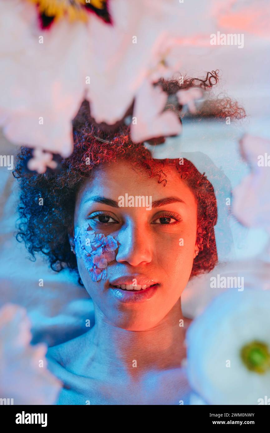 Young woman lying below glass surface under neon lights Stock Photo - Alamy