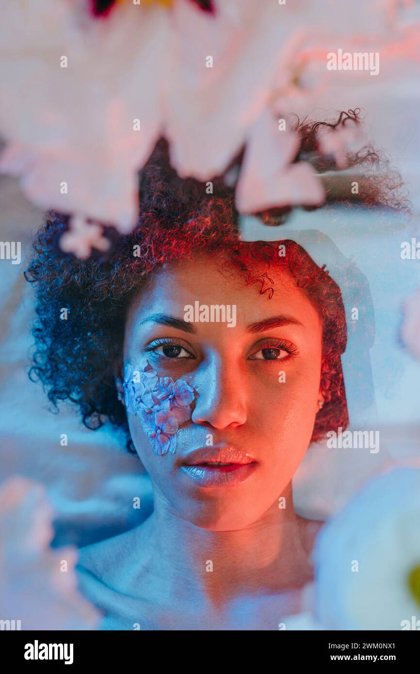 Beautiful woman lying below glass surface under neon lights Stock Photo ...