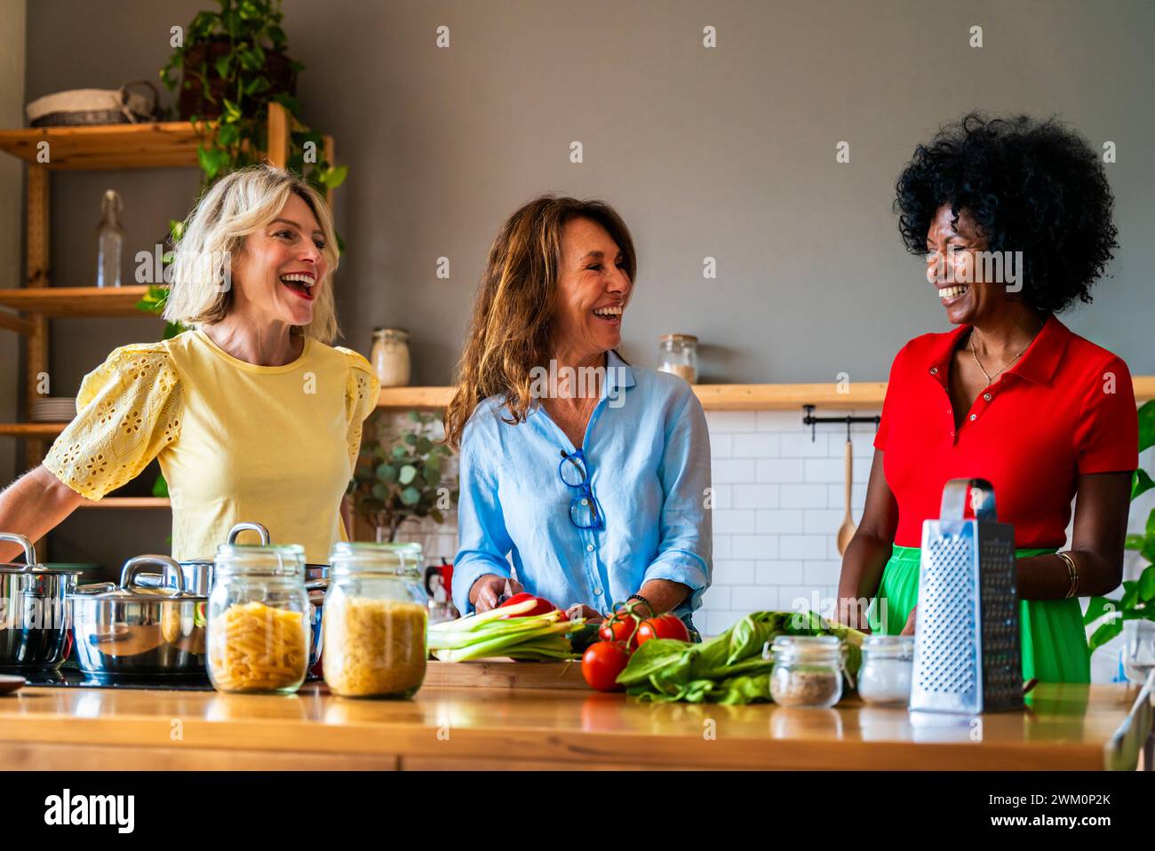 Happy women preparing food and laughing in kitchen at home Stock Photo ...
