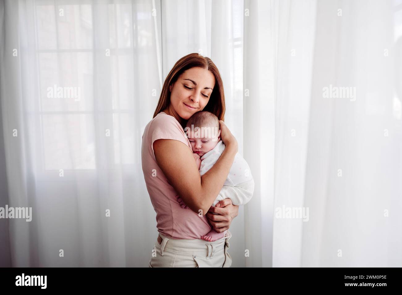 Mother embracing baby girl hi-res stock photography and images - Alamy