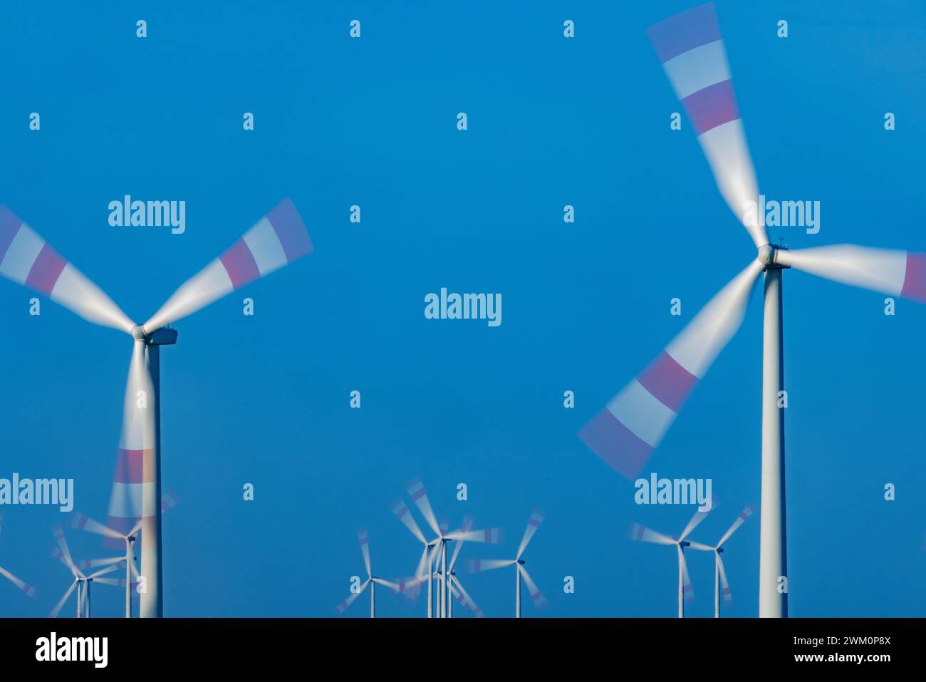 Wind farm turbines spinning against blue sky Stock Photo - Alamy