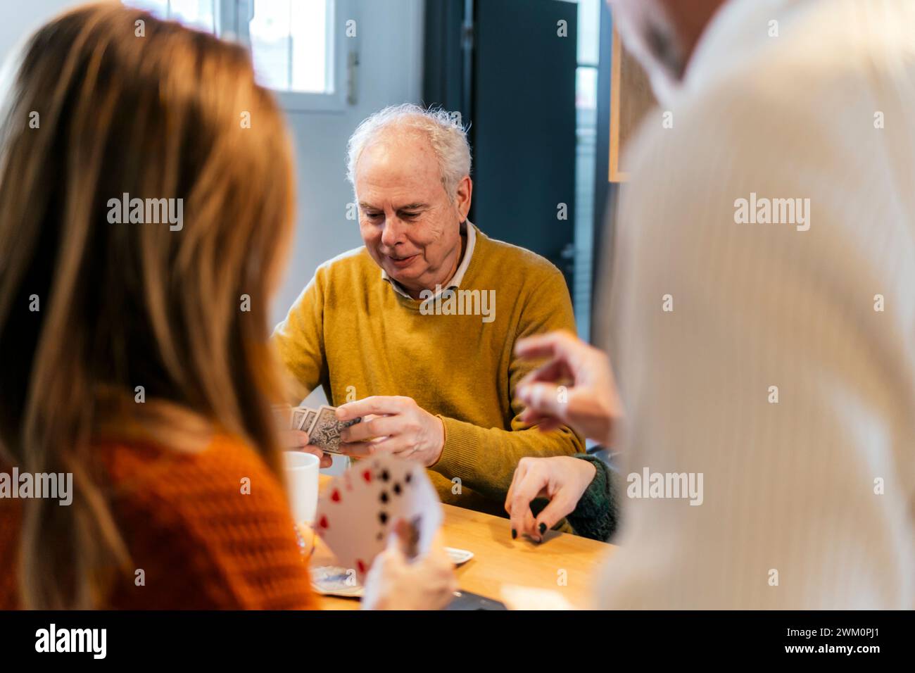 Friends playing cards together at home Stock Photo - Alamy