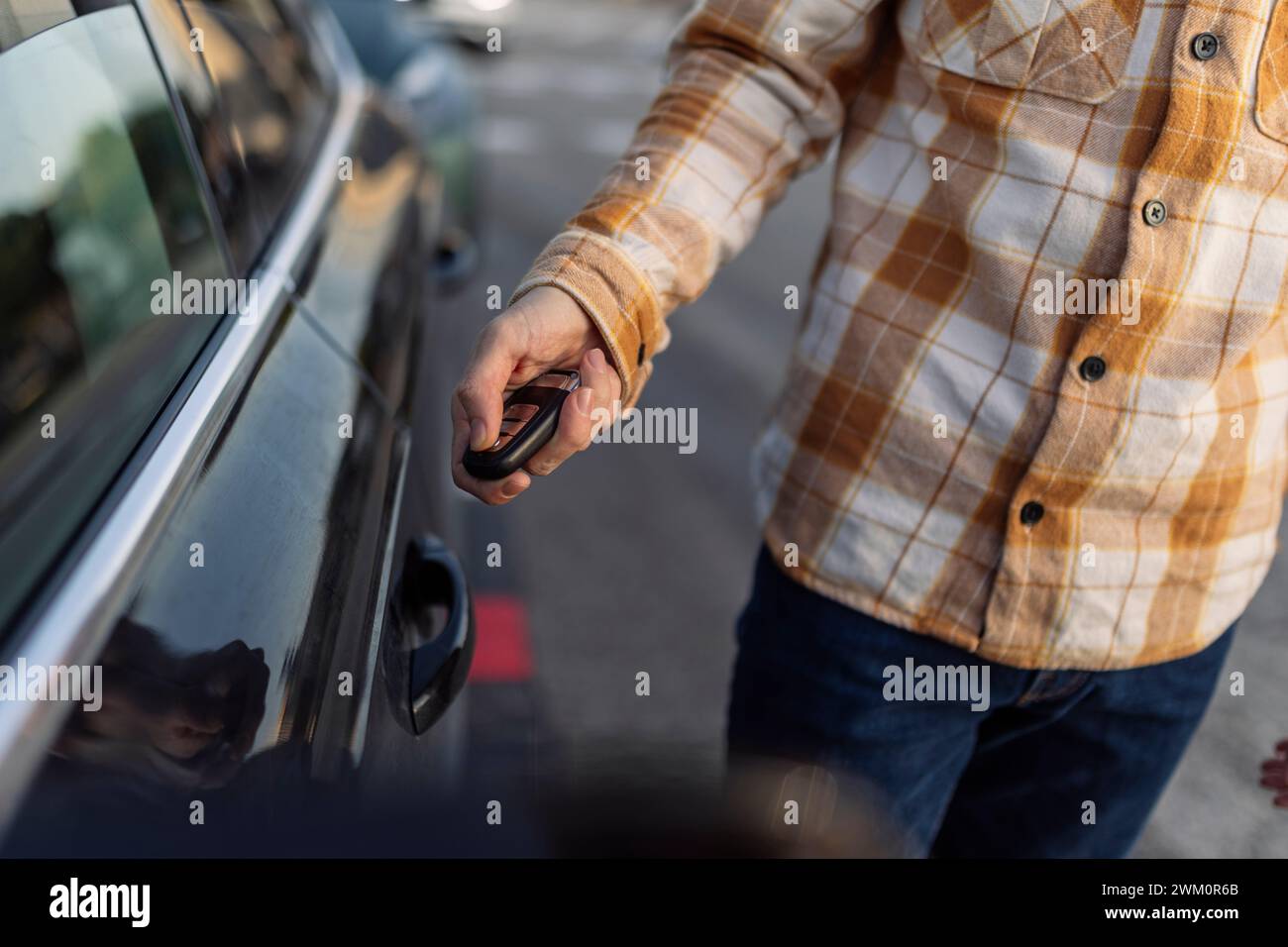 Man unlocking car with key on road Stock Photo - Alamy