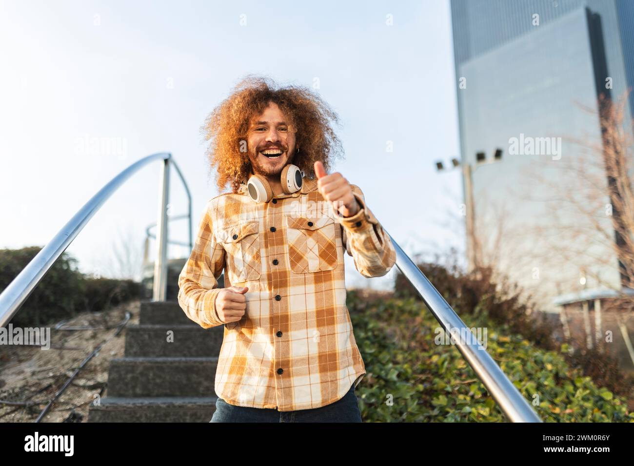 Happy man showing thumbs up gesture on staircase Stock Photo - Alamy