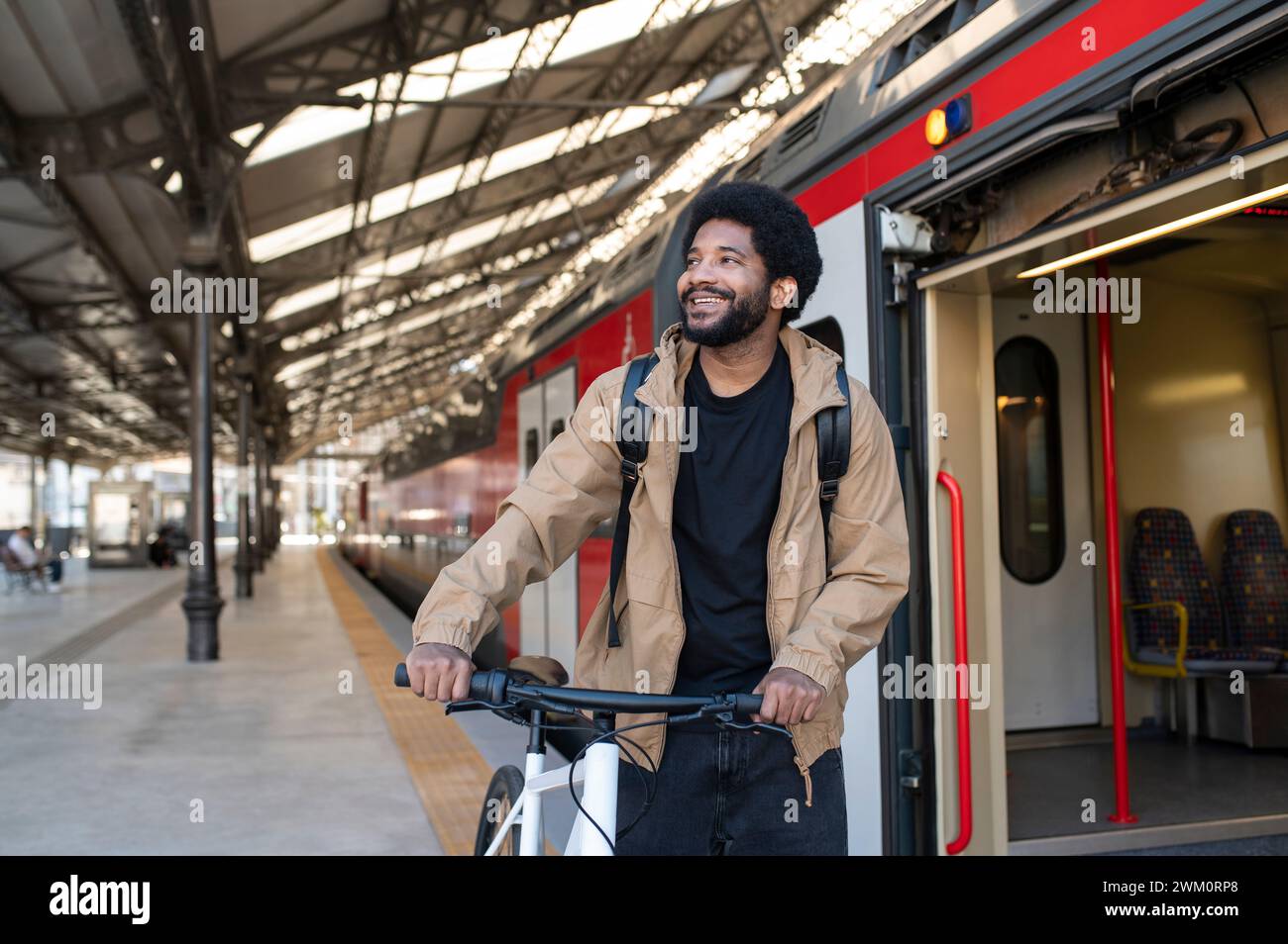 Smiling commuter wheeling bicycle near train at station Stock Photo - Alamy