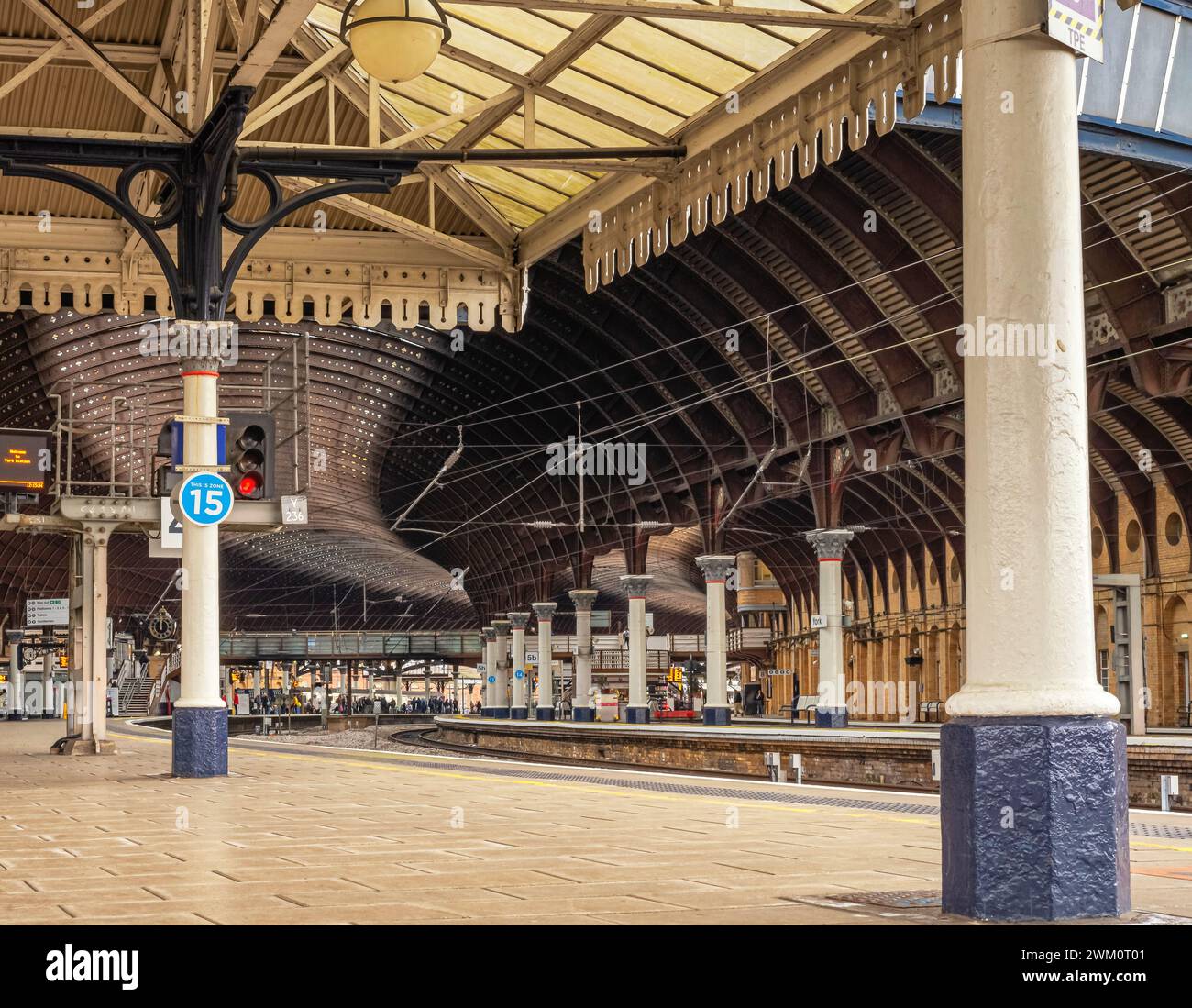 A railway station platform, lined by columns, curves, into a main ...