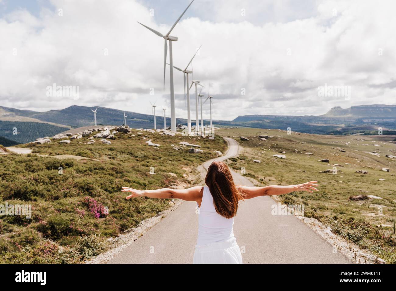 Spain, Madrid, Back of woman standing with raised arms in middle of ...